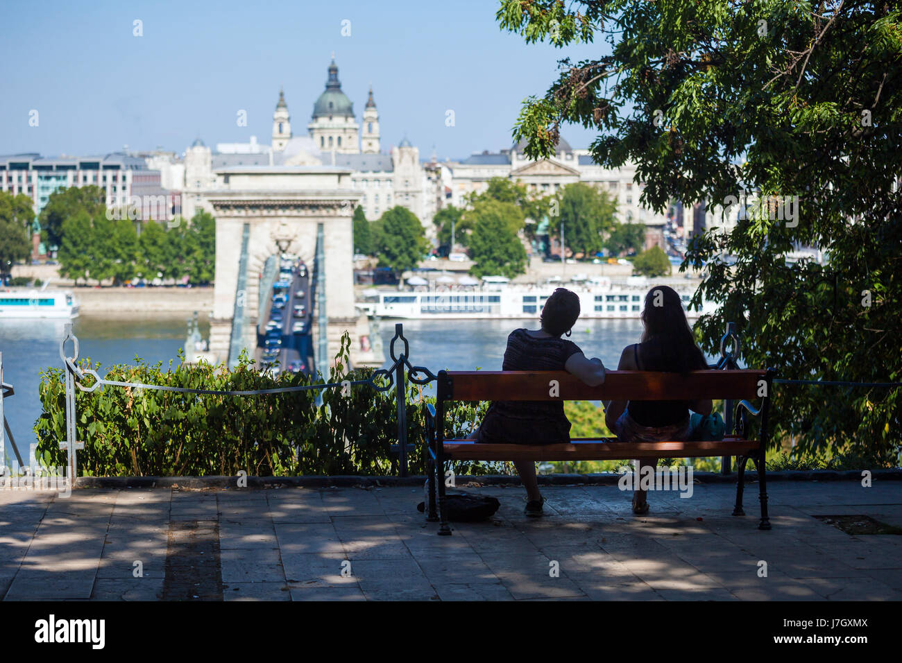 BUDAPEST, HUNGARY - AUGUST 2: Two girls on a bench watching at ...