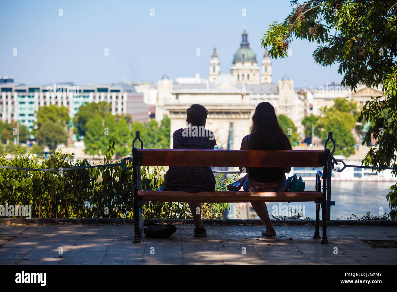 BUDAPEST, HUNGARY - AUGUST 2: Two girls on a bench watching at ...
