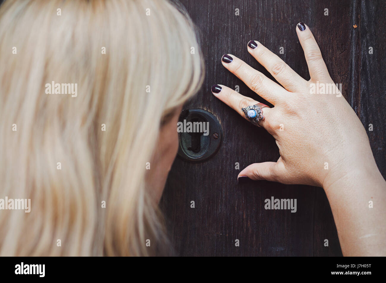 Woman looking through keyhole hi-res stock photography and images - Alamy
