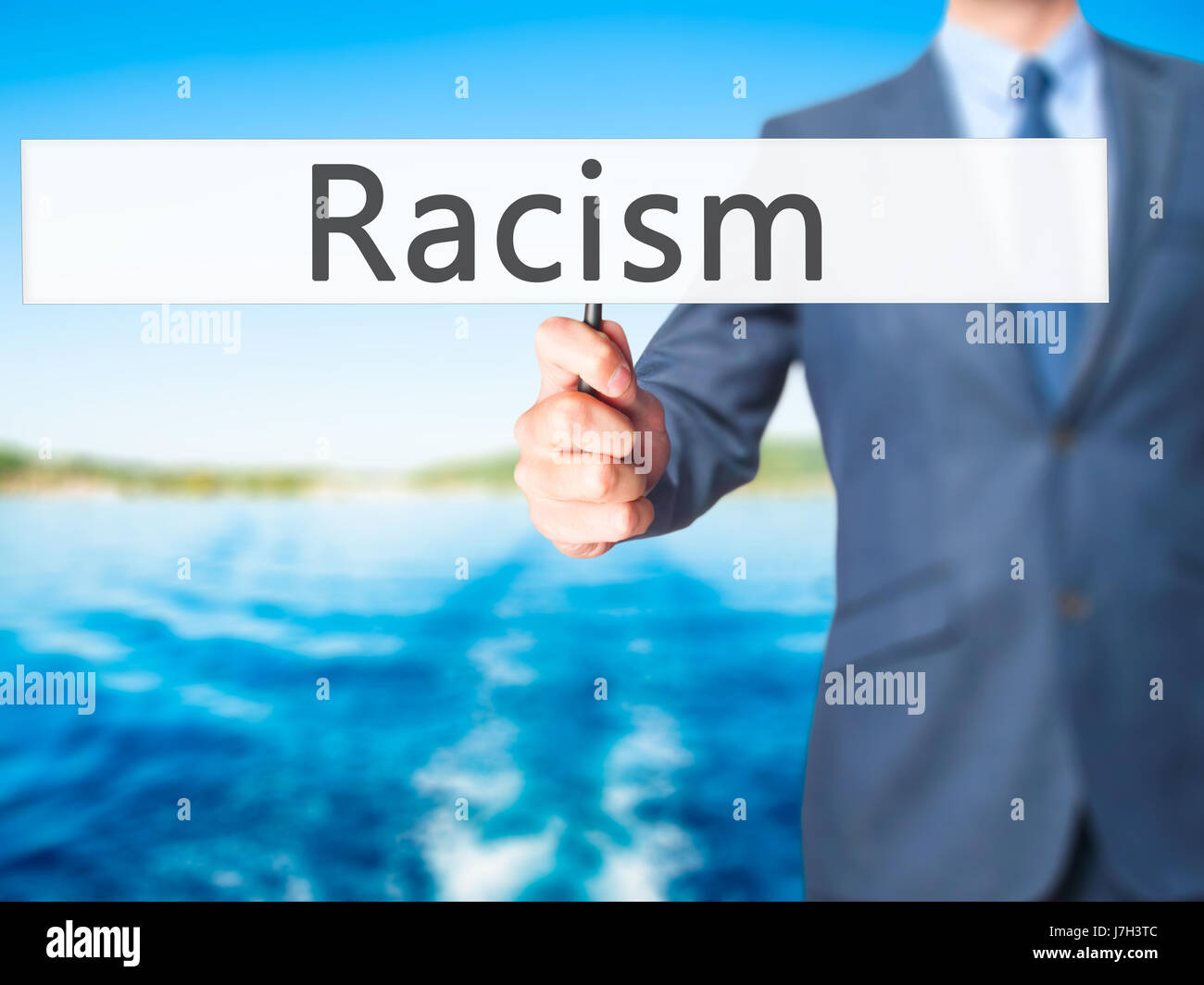 Racism - Businessman hand holding sign. Business, technology, internet ...