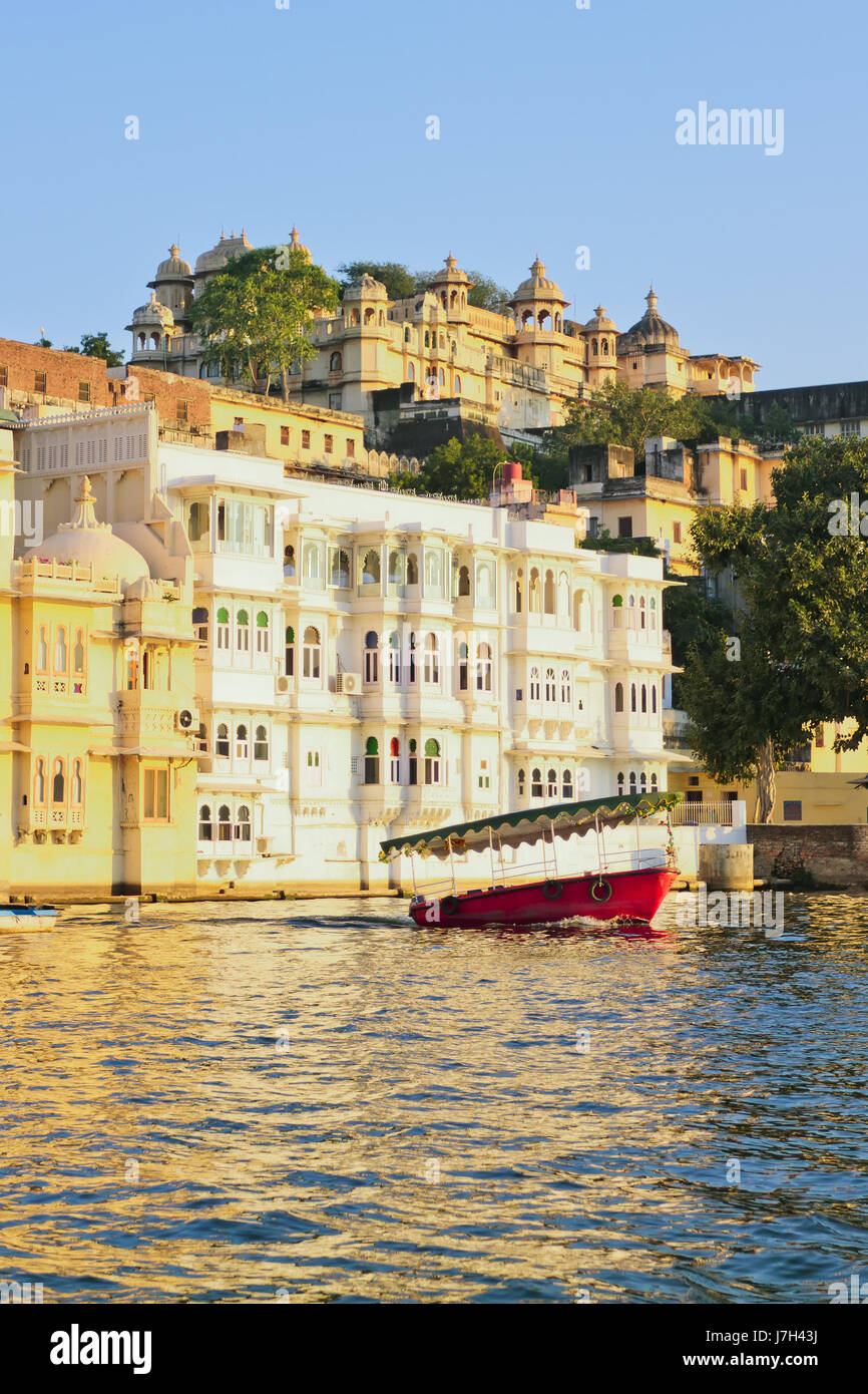 Beautiful water view of City Palace with touristic boat in Udaipur ...