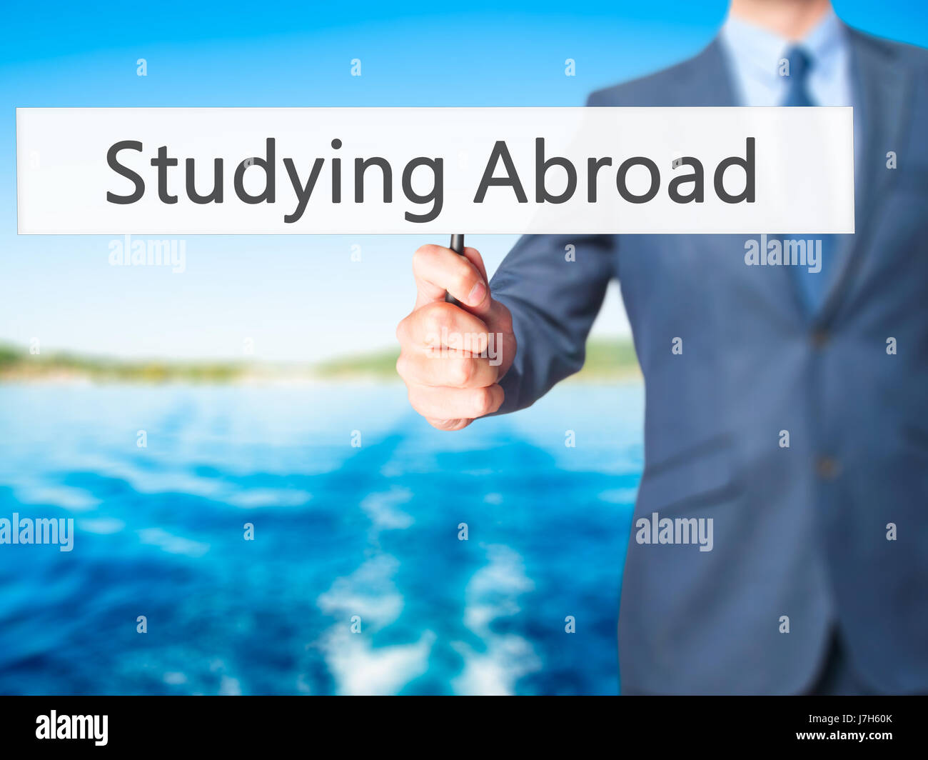 Studying Abroad - Businessman hand holding sign. Business, technology ...