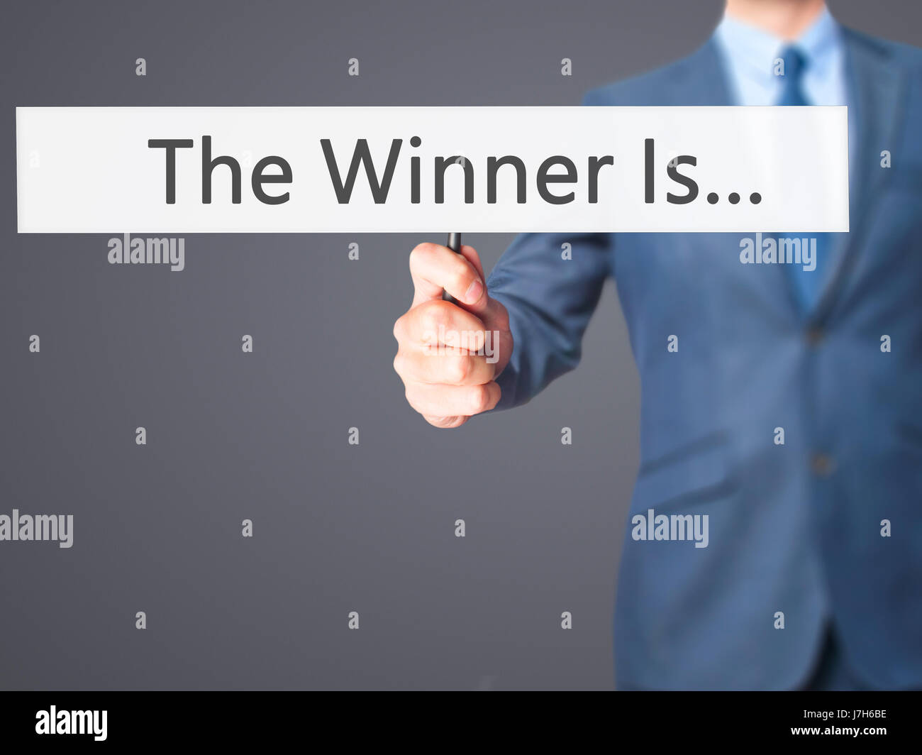 The Winner Is... - Businessman hand holding sign. Business, technology ...