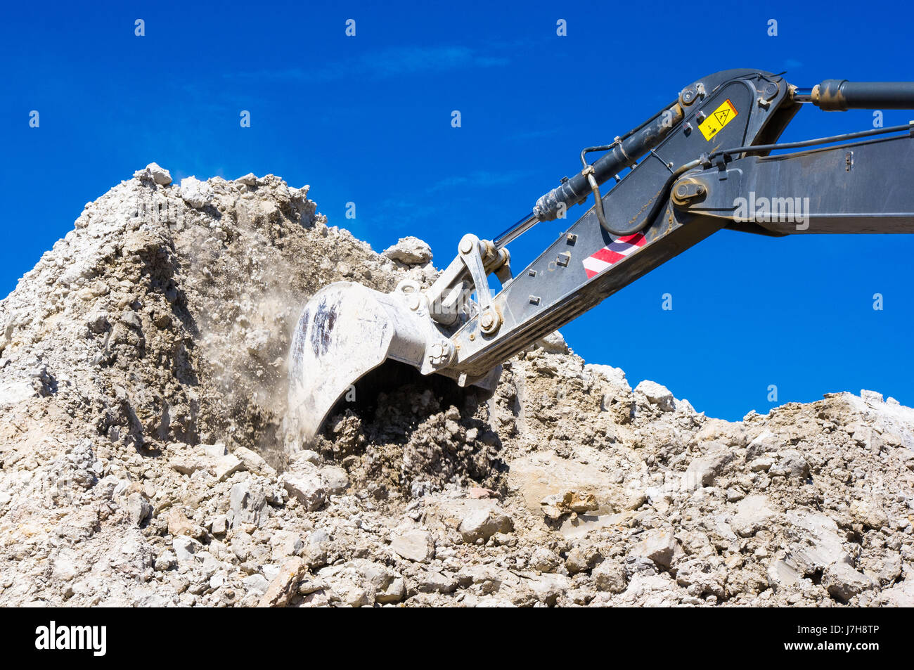 the excavator digging clay on blue sky background Stock Photo - Alamy
