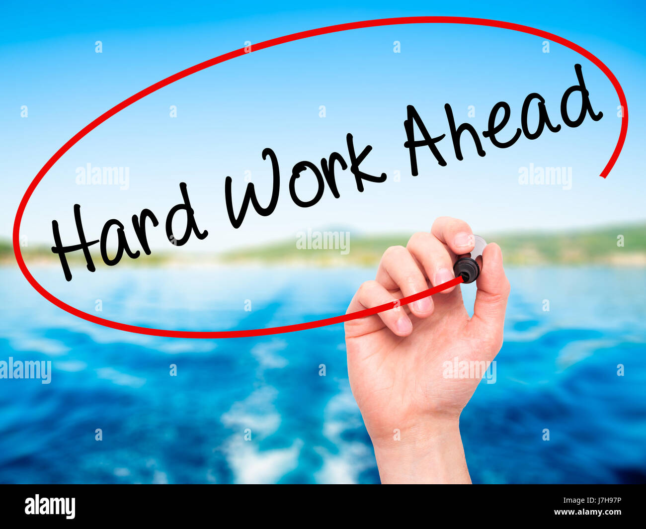 Man Hand writing Hard Work Ahead with black marker on visual screen ...