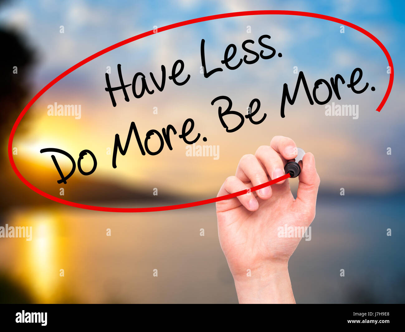 Man Hand writing Have Less. Do More. Be More. with black marker on ...