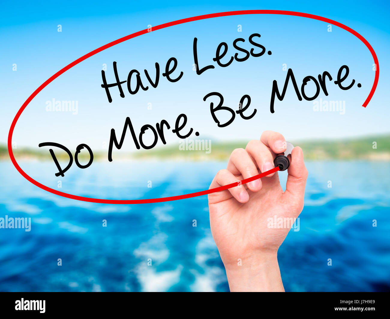 Man Hand writing Have Less. Do More. Be More. with black marker on ...