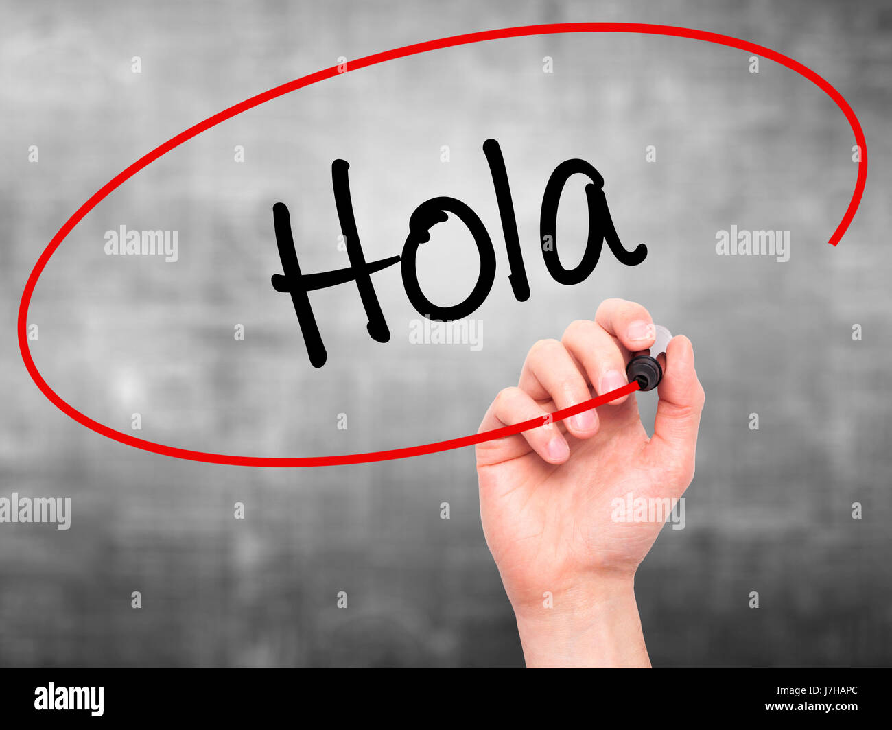 Man Hand writing Hola (Hello in Spanish) with black marker on visual ...