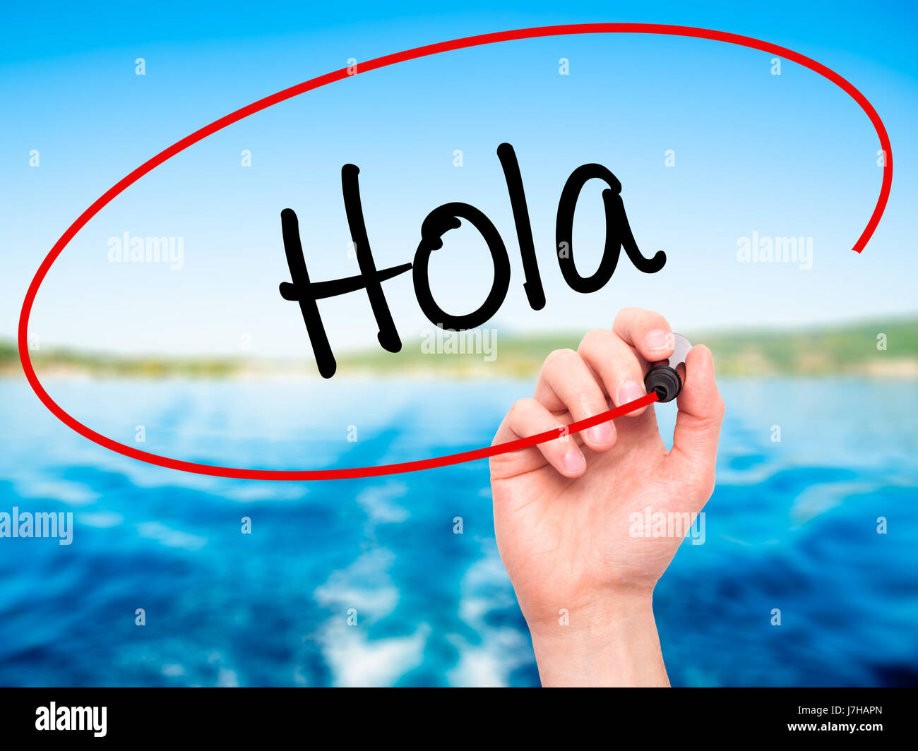 Man Hand writing Hola (Hello in Spanish) with black marker on visual ...