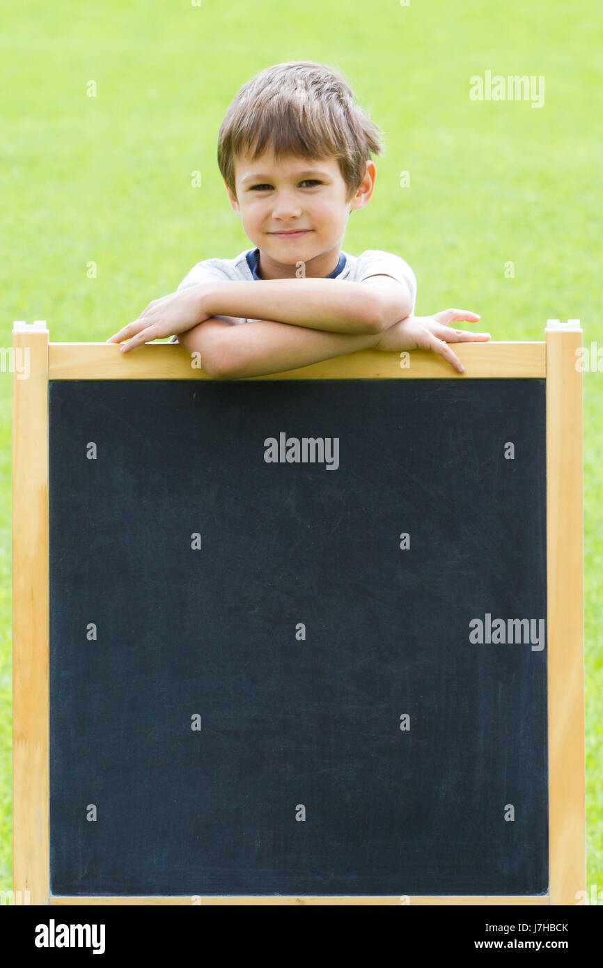 Happy kid standing at the blackboard Stock Photo - Alamy