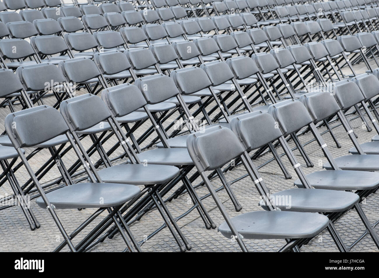 rows of empty chairs - black folding chairs Stock Photo - Alamy