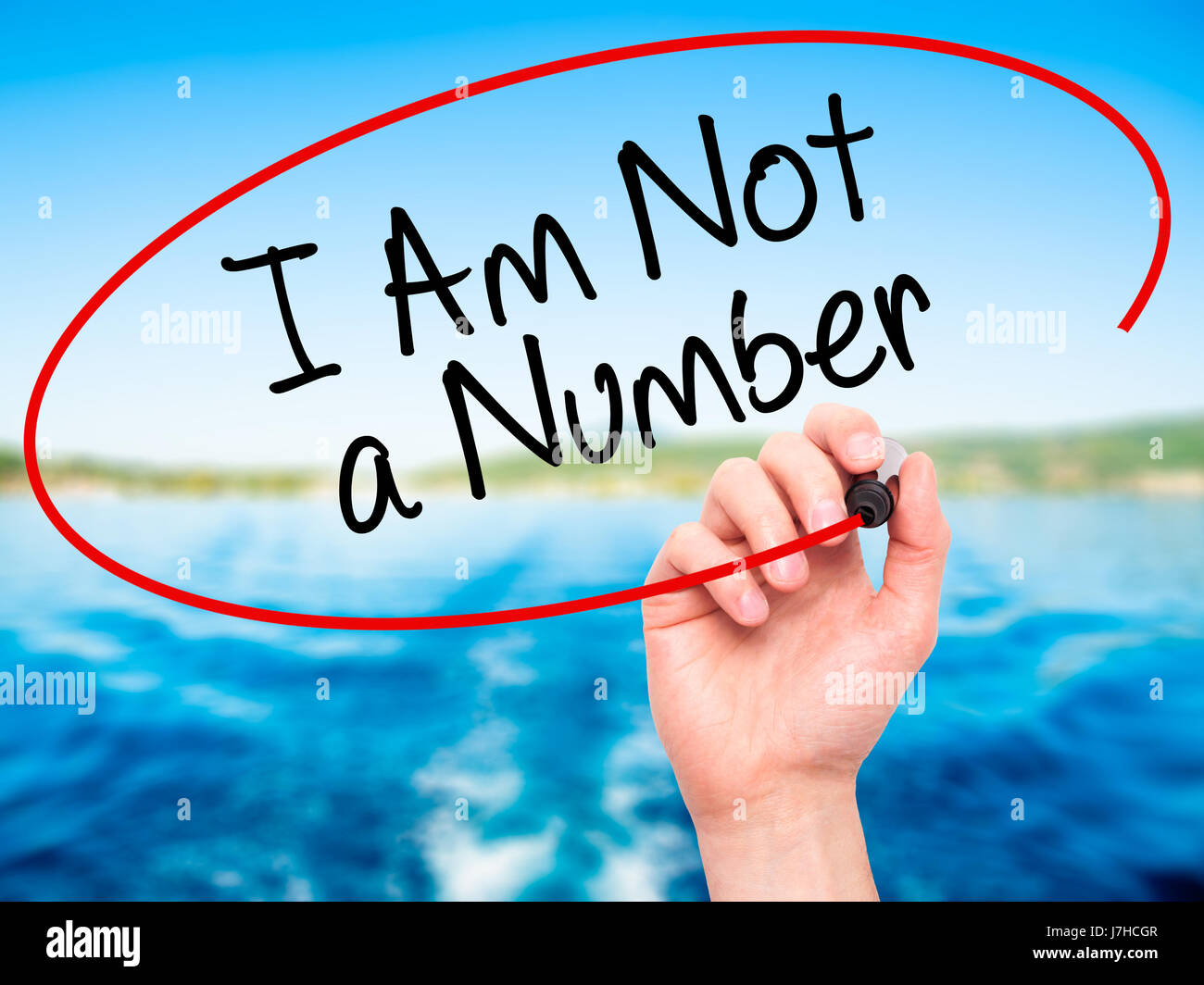 Man Hand writing I Am Not a Number with black marker on visual screen ...