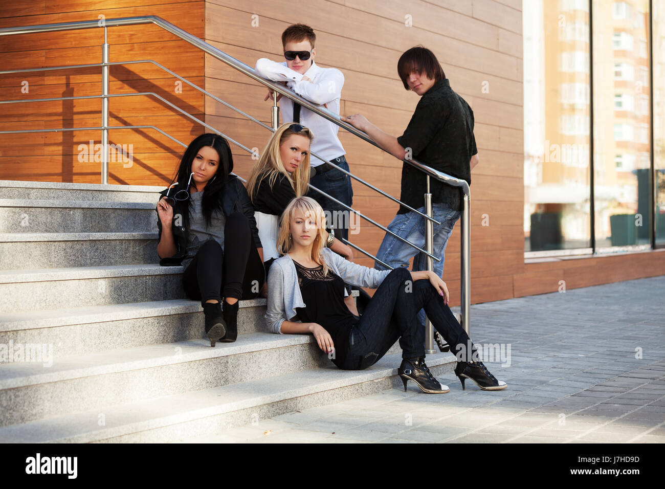 Young people sitting on the steps Stock Photo - Alamy