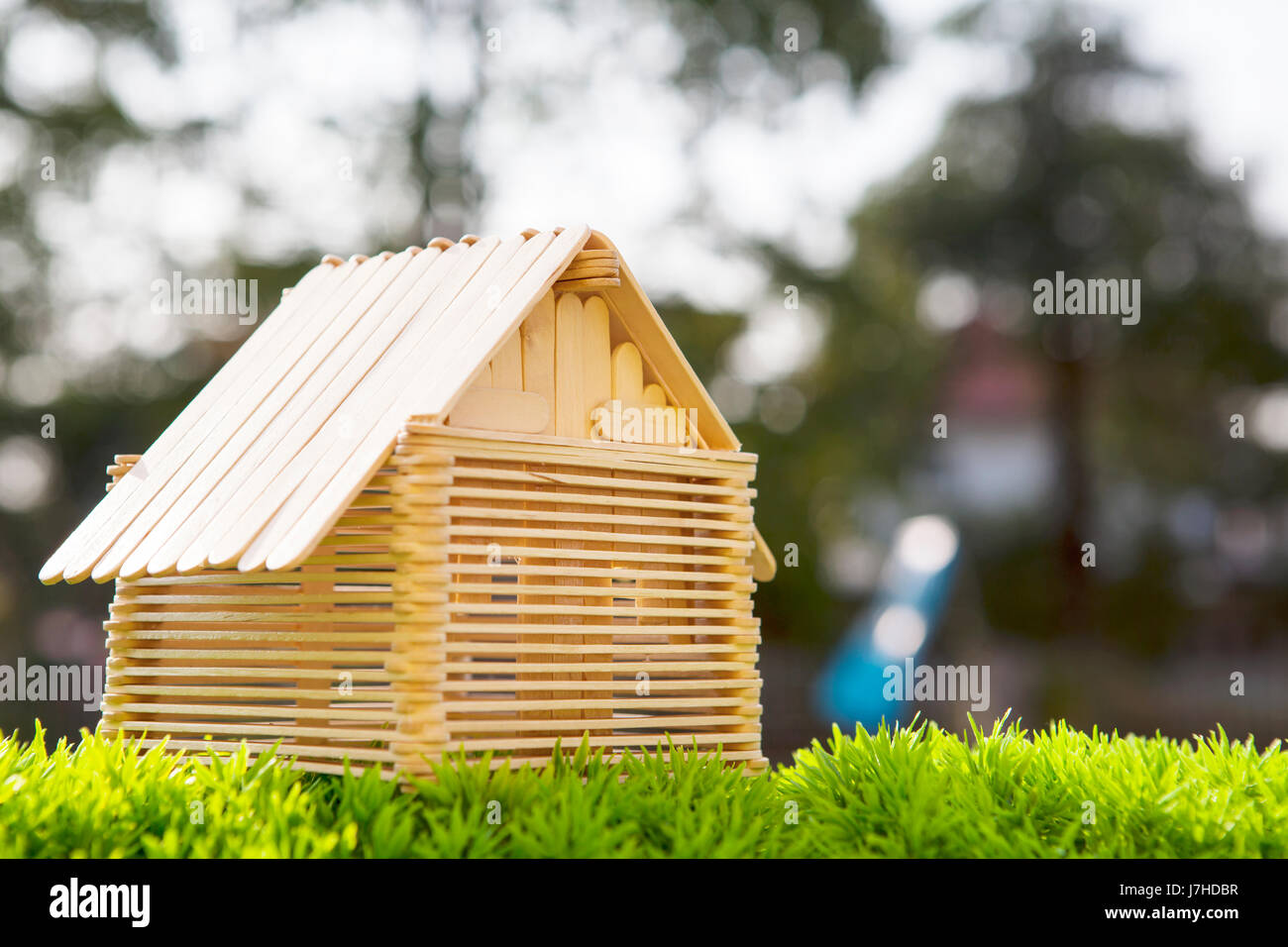 house model make from wood stick on artificial grass field with blurry ...