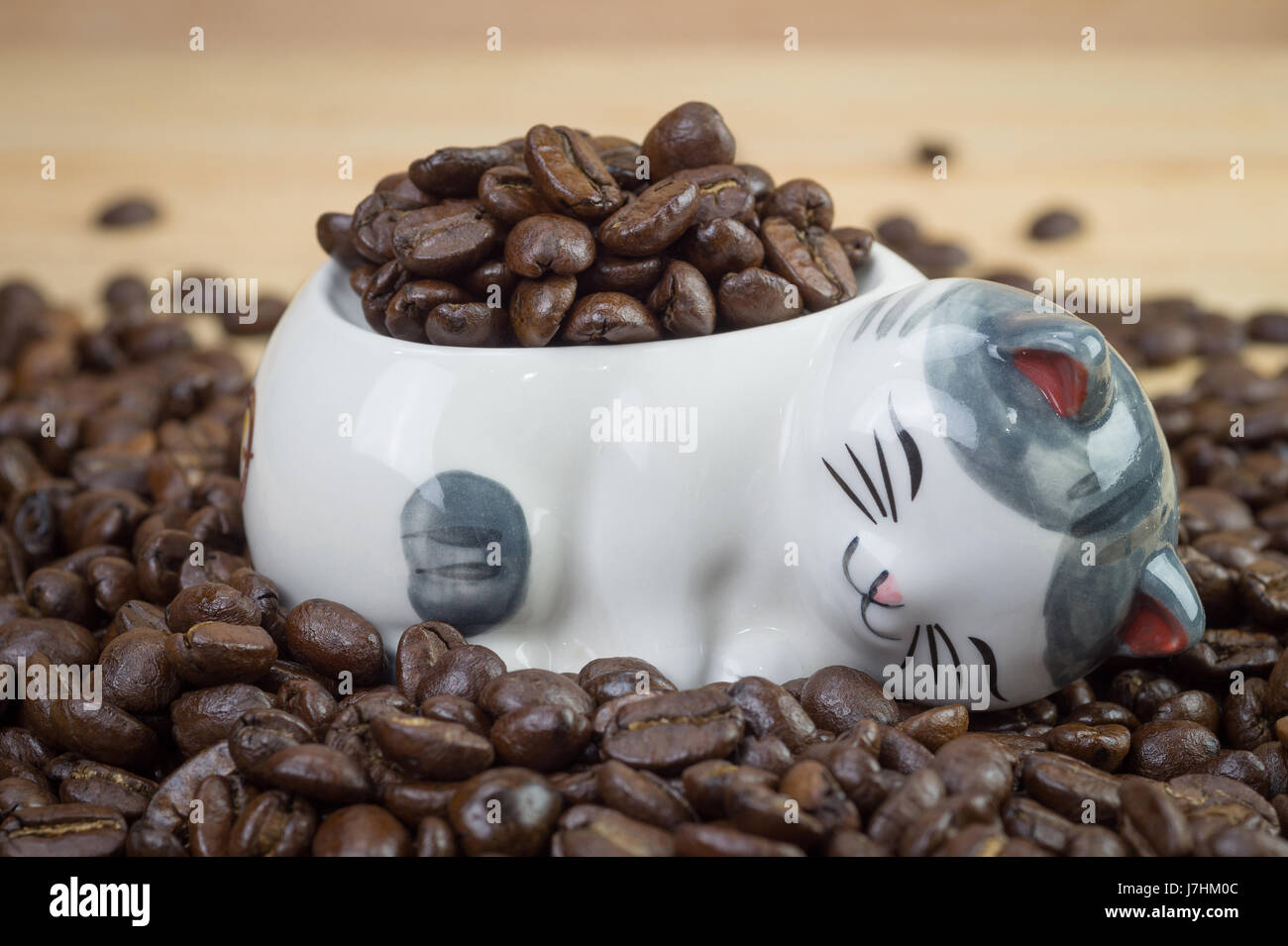Coffee beans in cat ceramic pot on wood background Stock Photo - Alamy