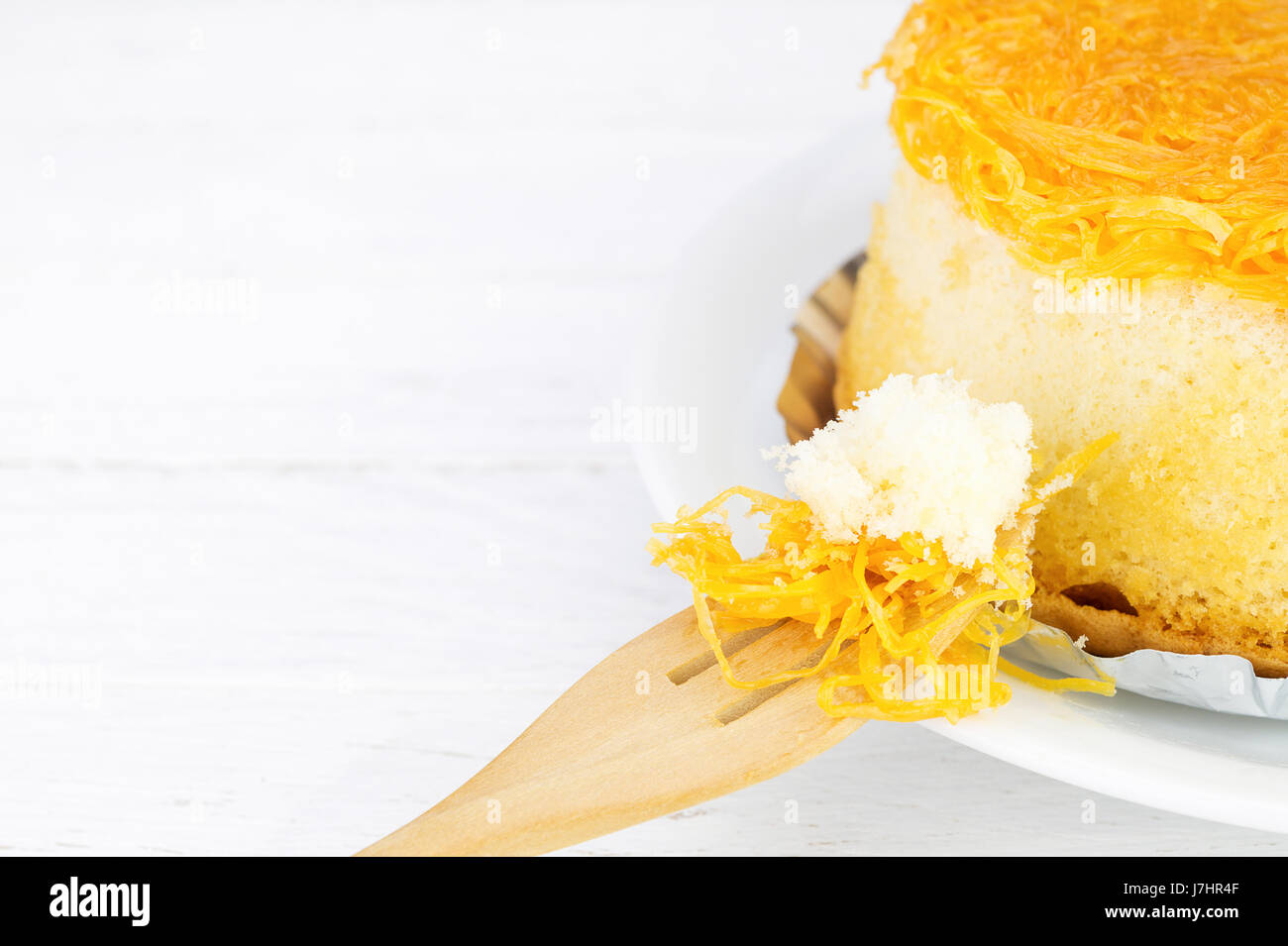 Gold egg yolks thread cake on white wood background Stock Photo - Alamy