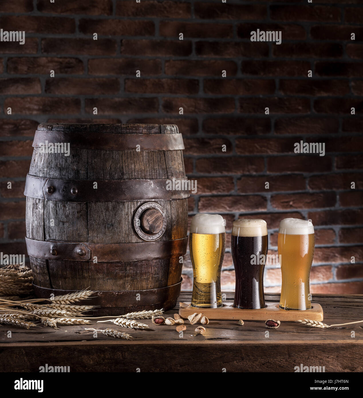 Glasses of beer and ale barrel on the wooden table. Craft brewery Stock ...
