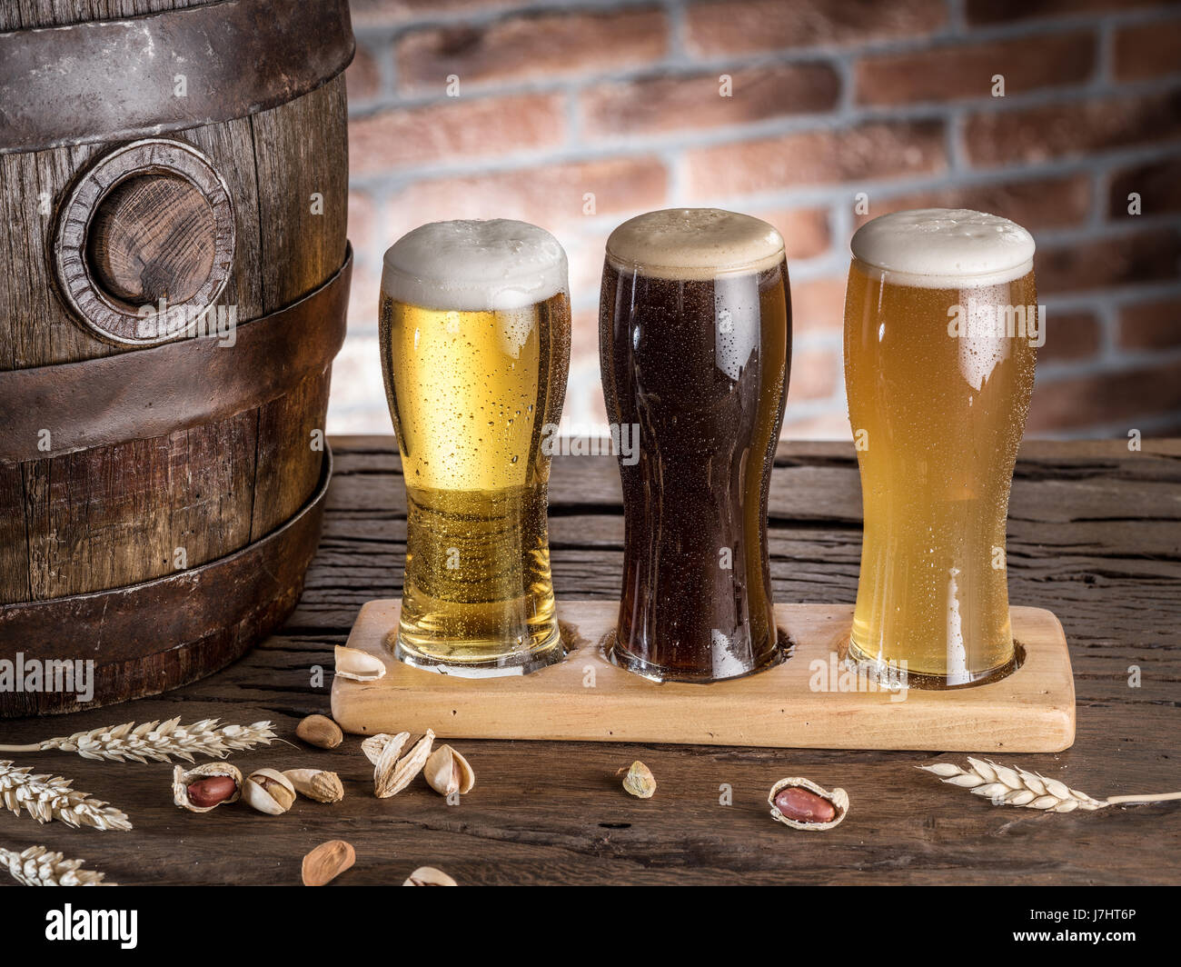 Glasses of beer and ale barrel on the wooden table. Craft brewery Stock ...