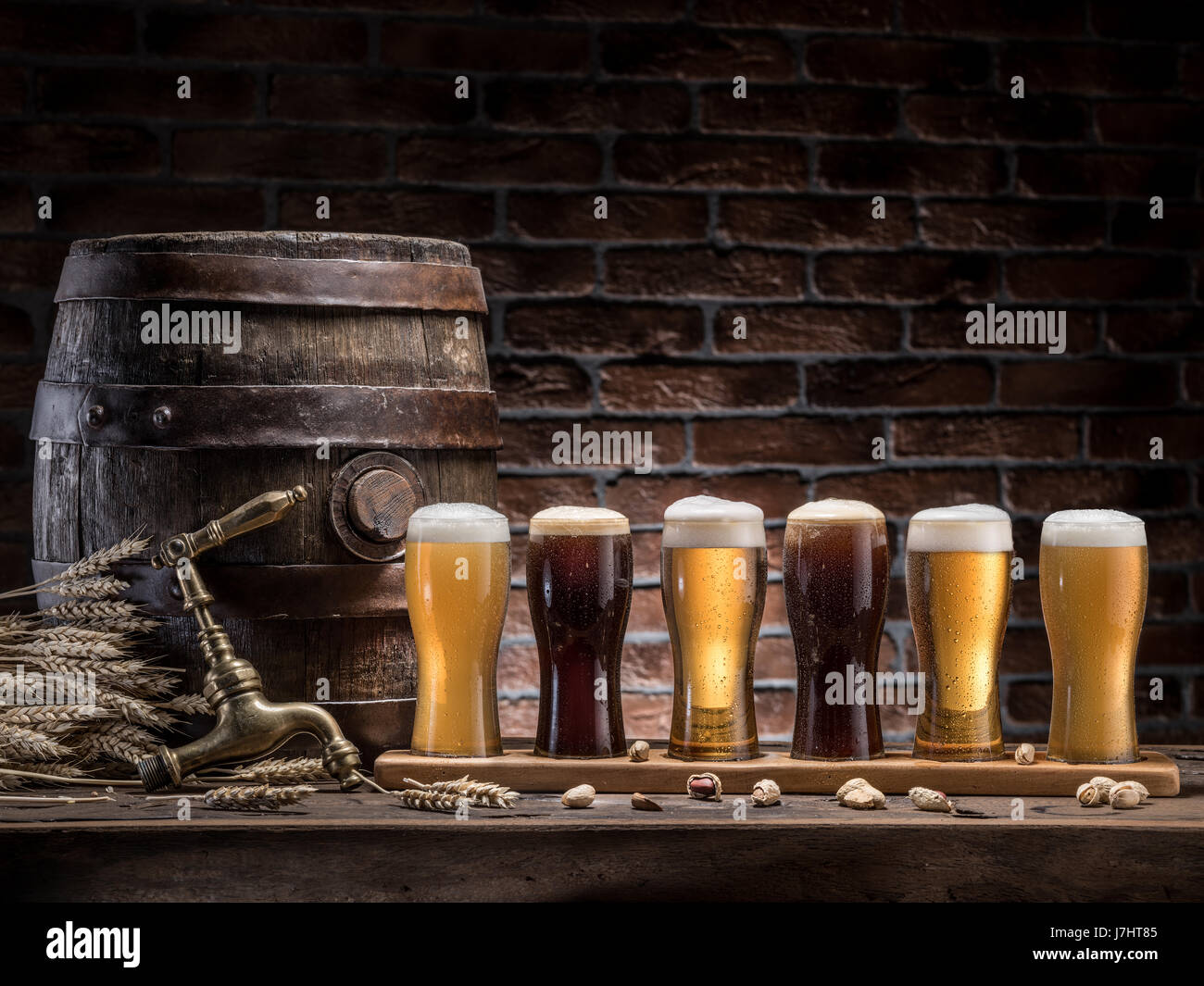 Glasses of beer and ale barrel on the wooden table. Craft brewery Stock ...