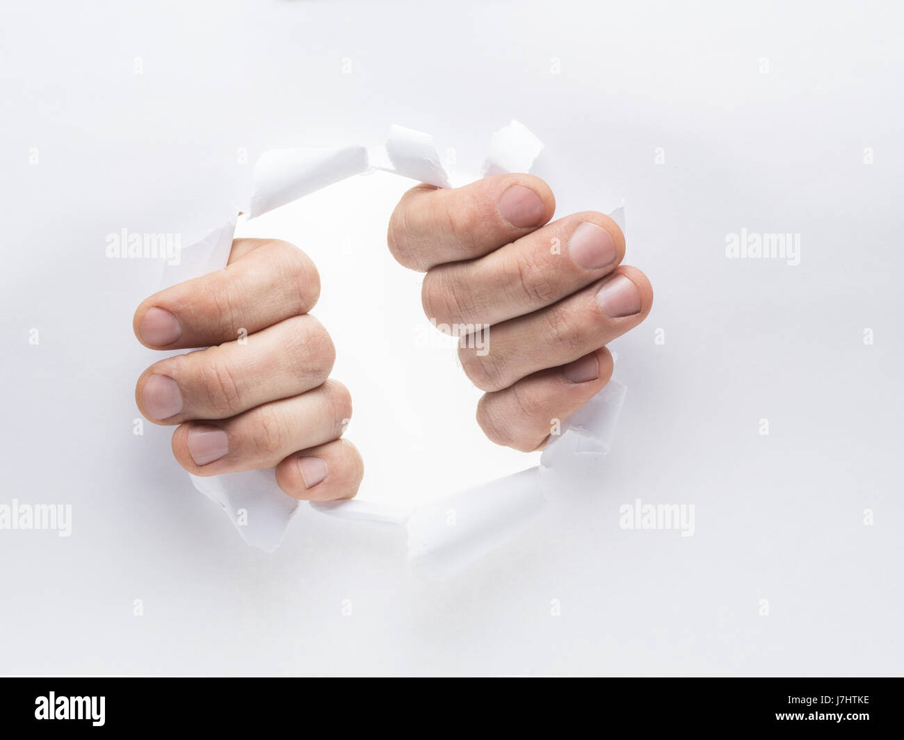 Man's hands tearing the hole on a paper Stock Photo - Alamy