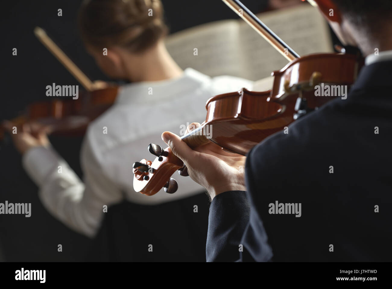 Violinists playing at the concert, rear view Stock Photo - Alamy