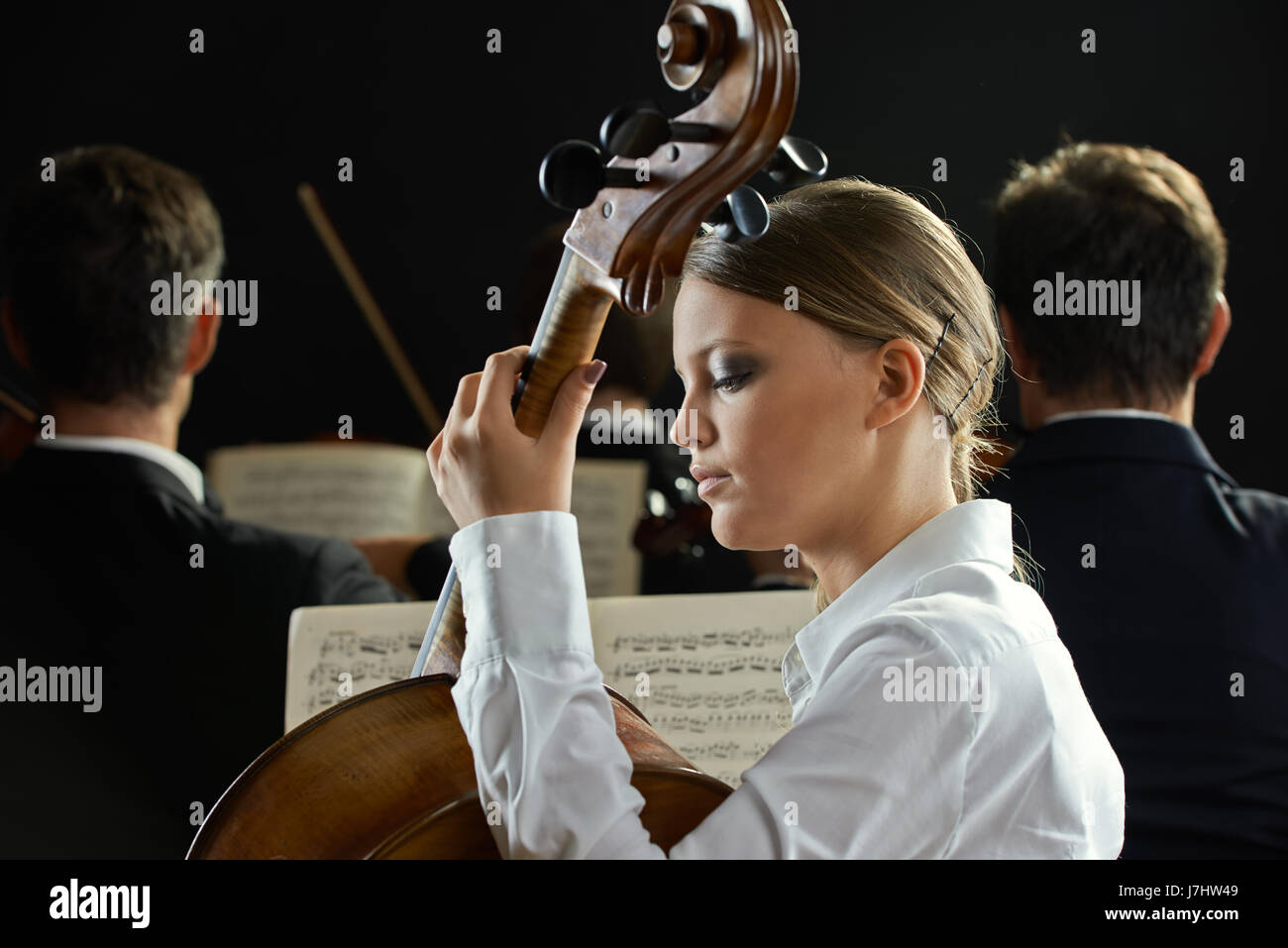 Young beautiful woman playing cello in orchestra Stock Photo - Alamy