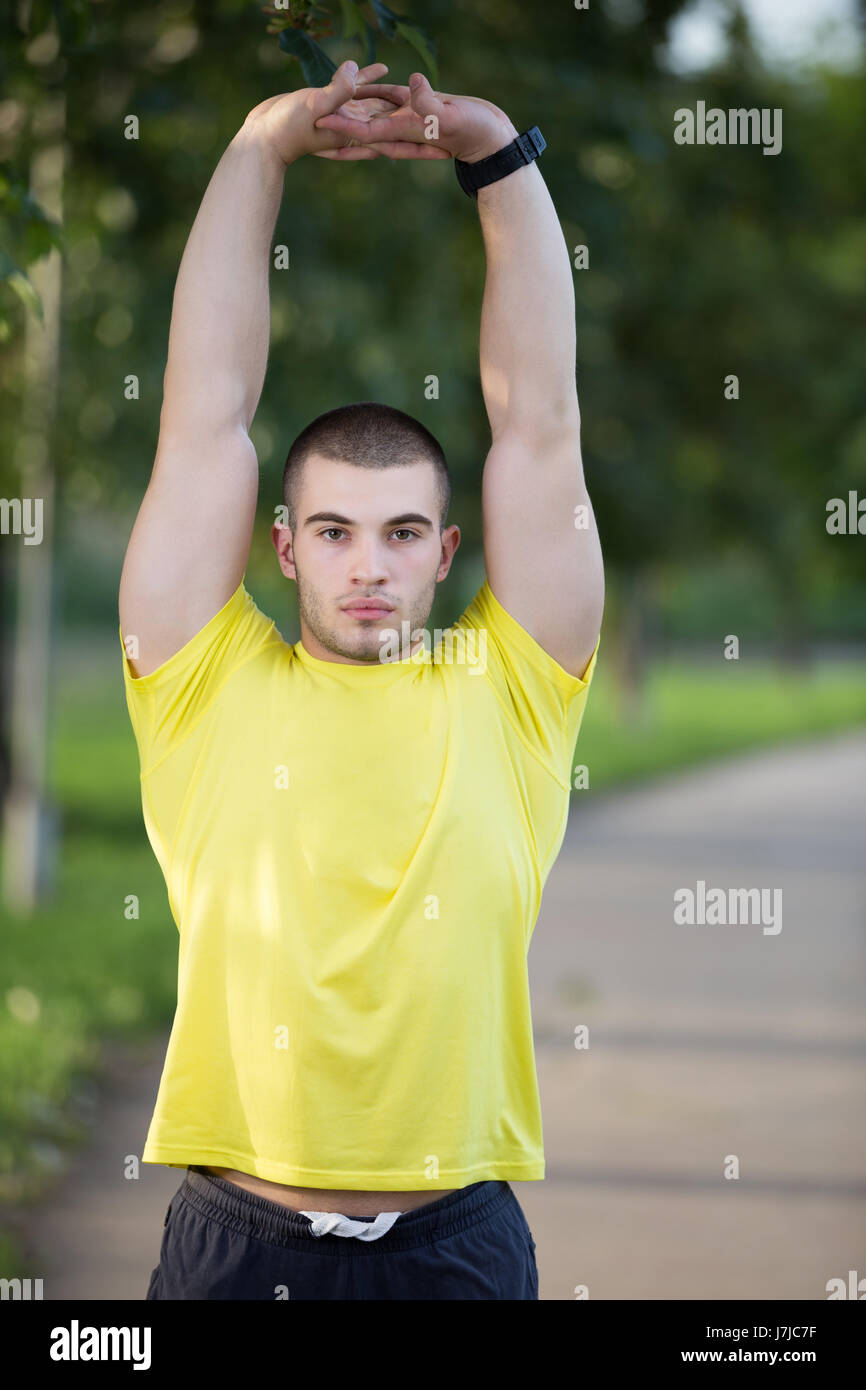 Fitness man stretching arm shoulder before outdoor workout. Sporty male ...