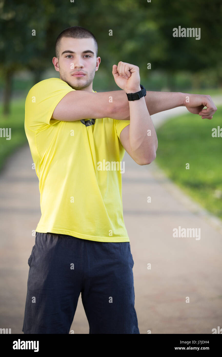 Fitness man stretching arm shoulder before outdoor workout. Sporty male ...