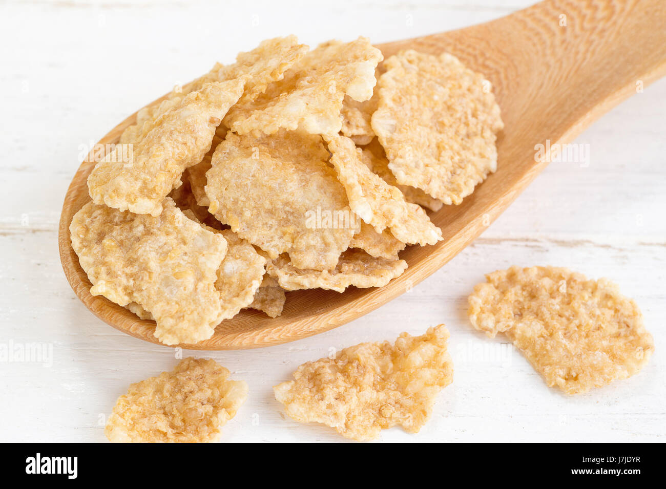 whole wheat grain flakes in wooden spoon on white wood background Stock ...