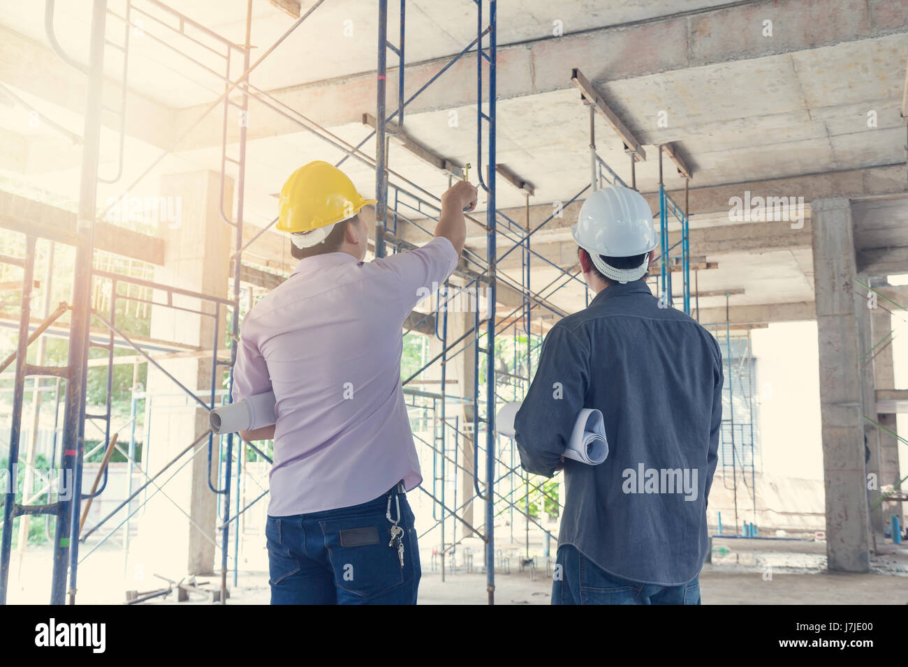 Construction concepts, Engineer and Architect working at Construction Site with blueprint ...