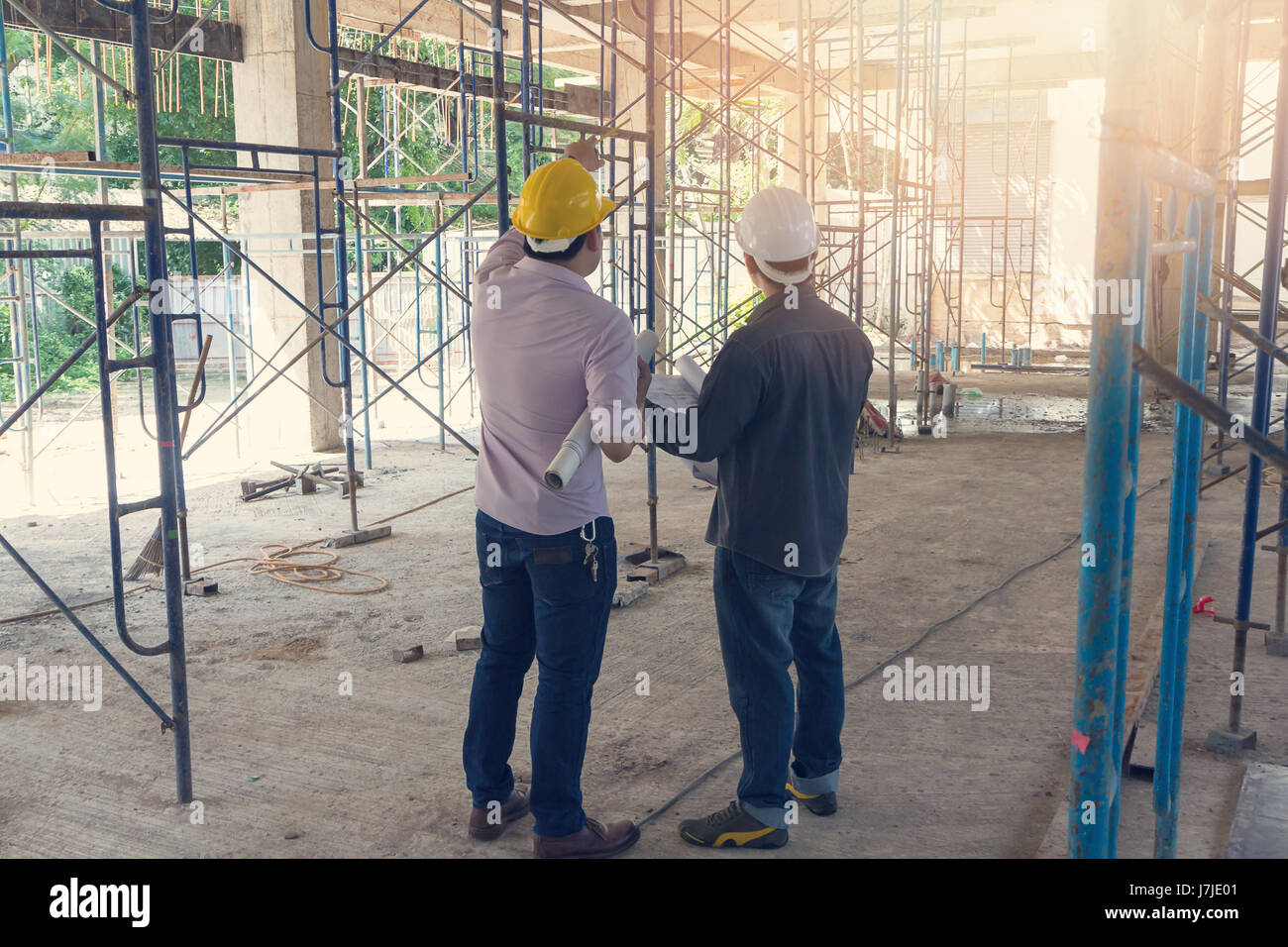 Construction concepts, Engineer and Architect working at Construction Site with blueprint ...