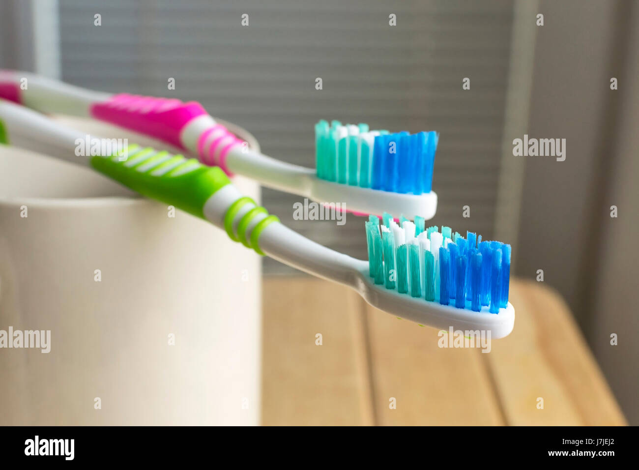 Toothbrushes in the white cup Stock Photo - Alamy