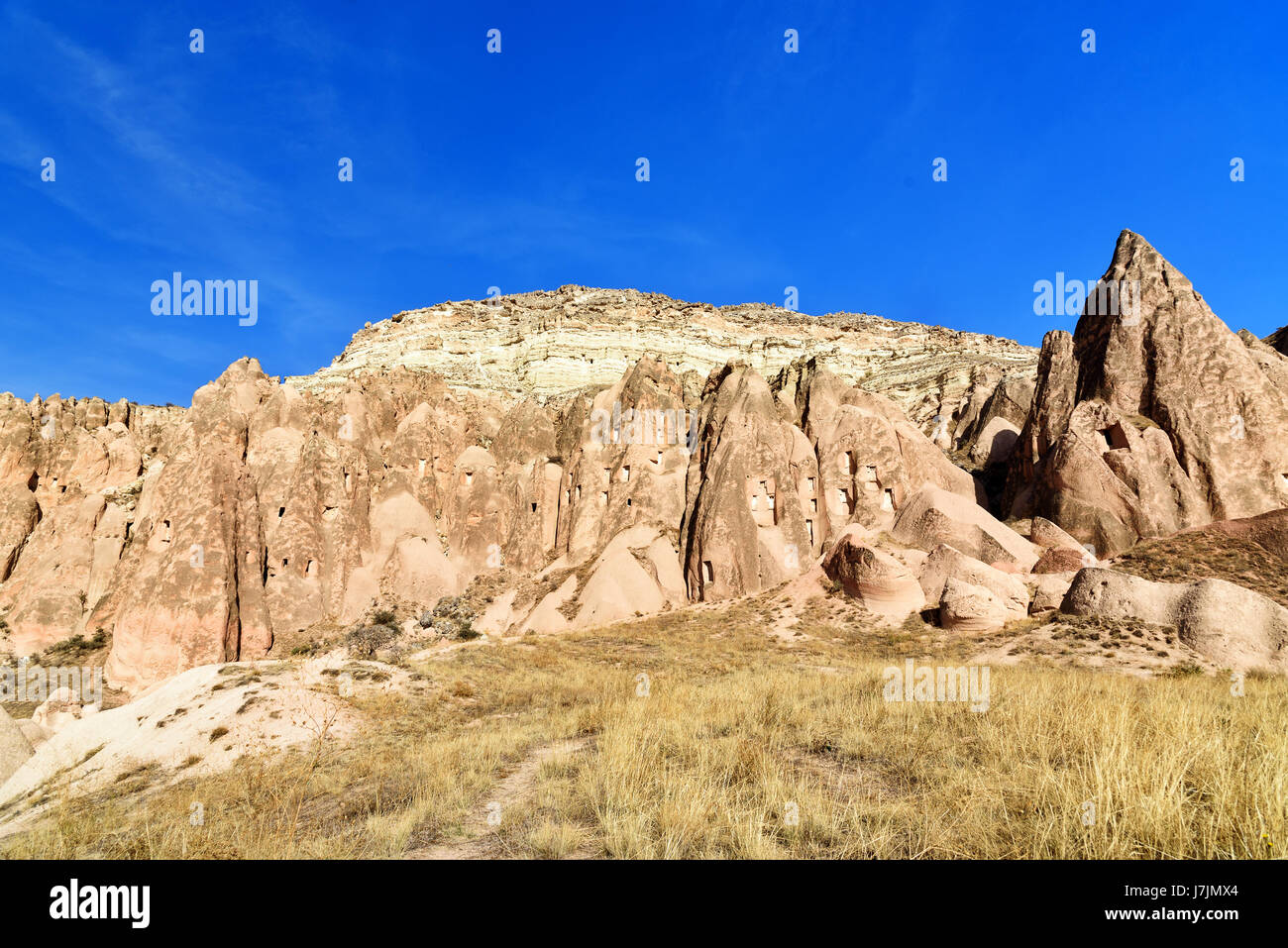 View of cave houses in mountain formations in valley at Cavusin ...