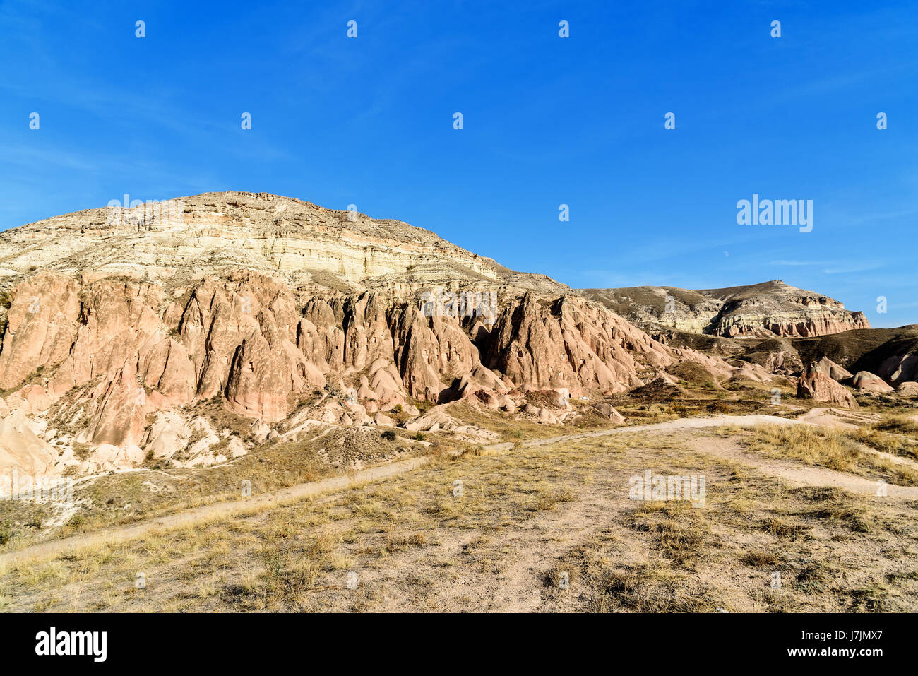 View of cave houses in mountain formations in valley at Cavusin ...