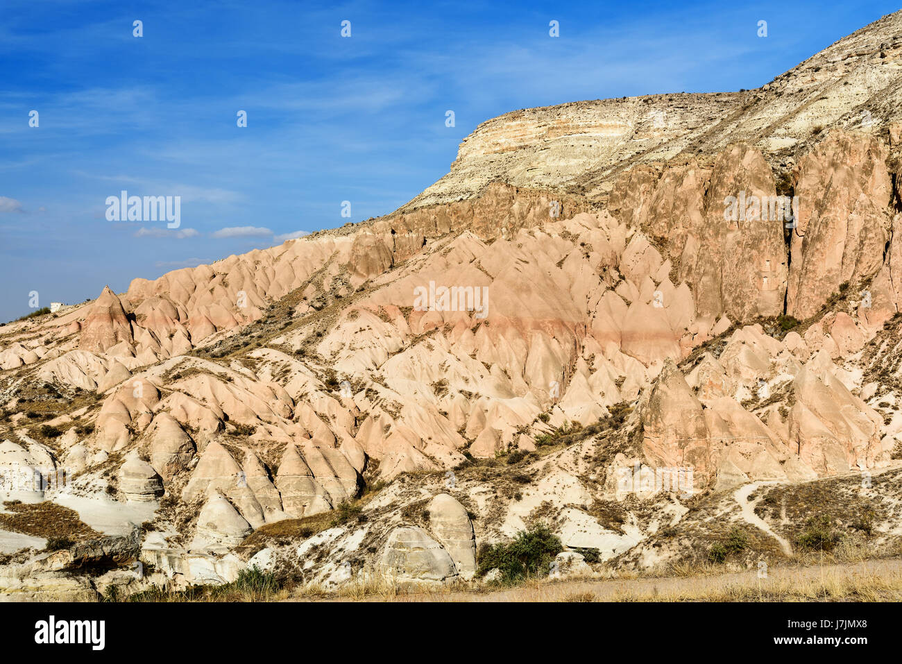 View of cave houses in mountain formations in valley at Cavusin ...
