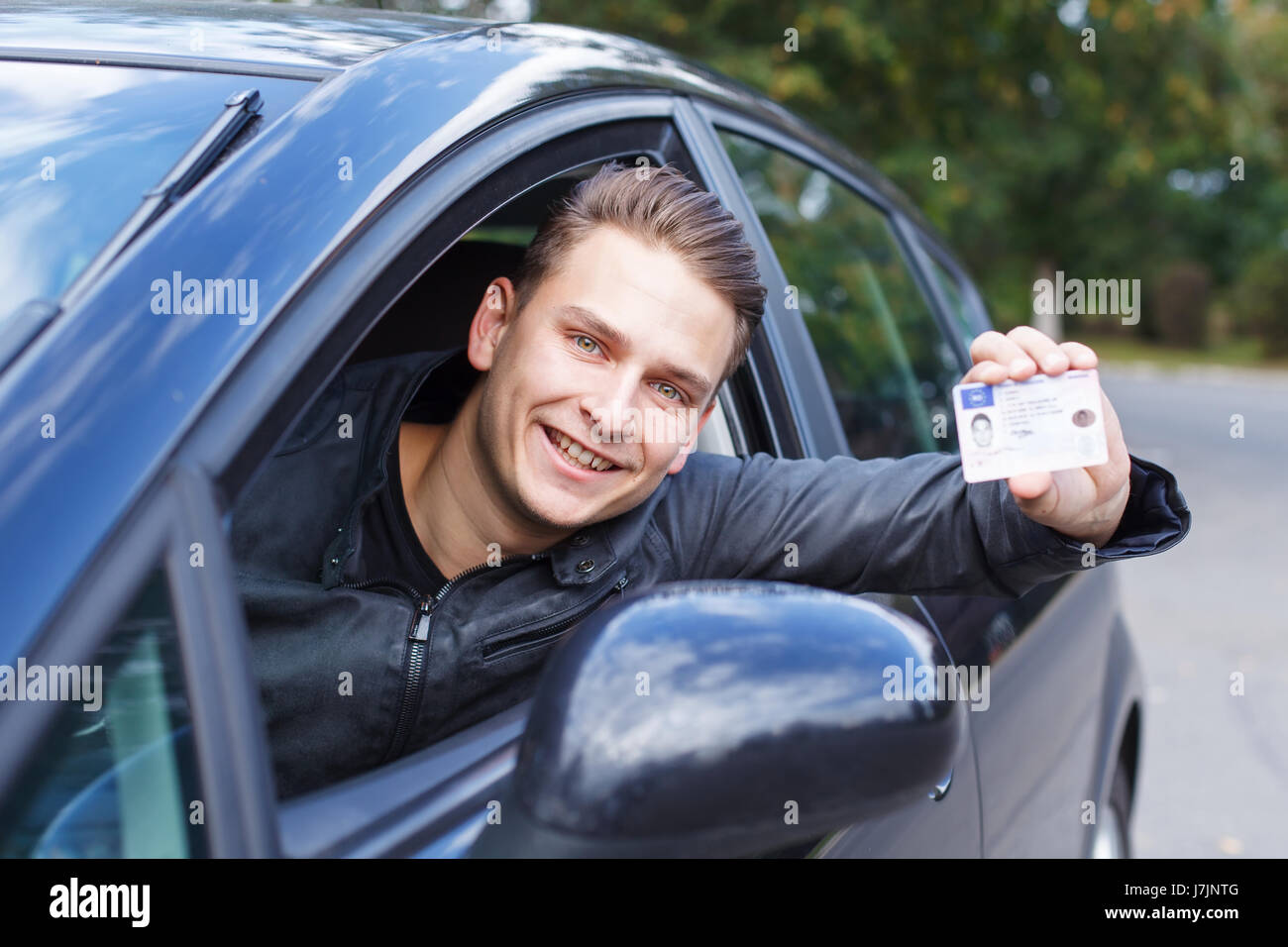 Portrait of a handsome young man driving a car Stock Photo - Alamy