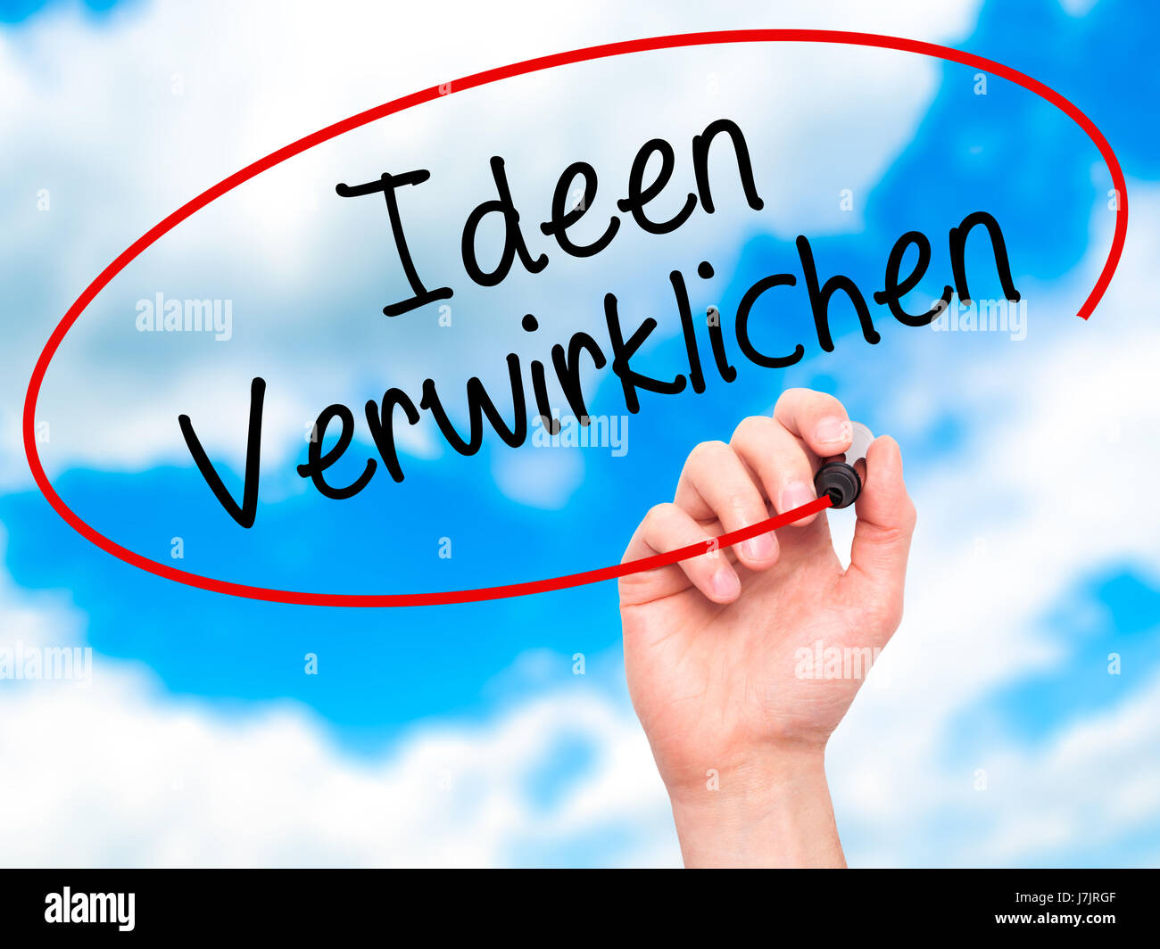 Man Hand writing Ideen Verwirklichen ( Realize Ideas in German) with ...
