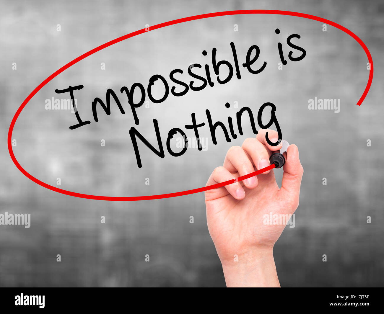 Man Hand writing Impossible is Nothing with black marker on visual ...