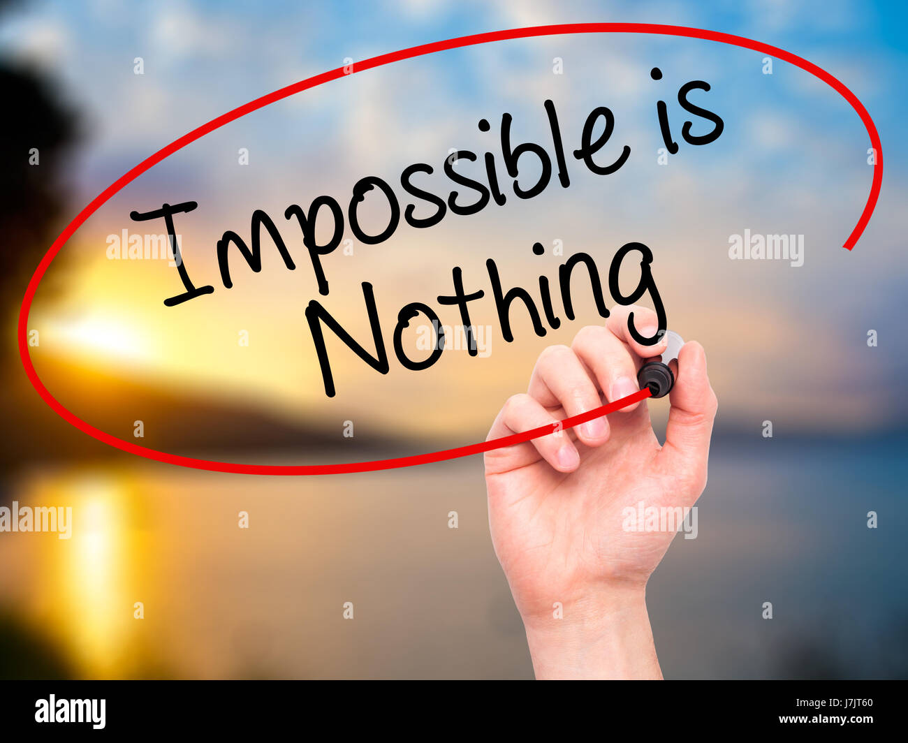 Man Hand writing Impossible is Nothing with black marker on visual ...