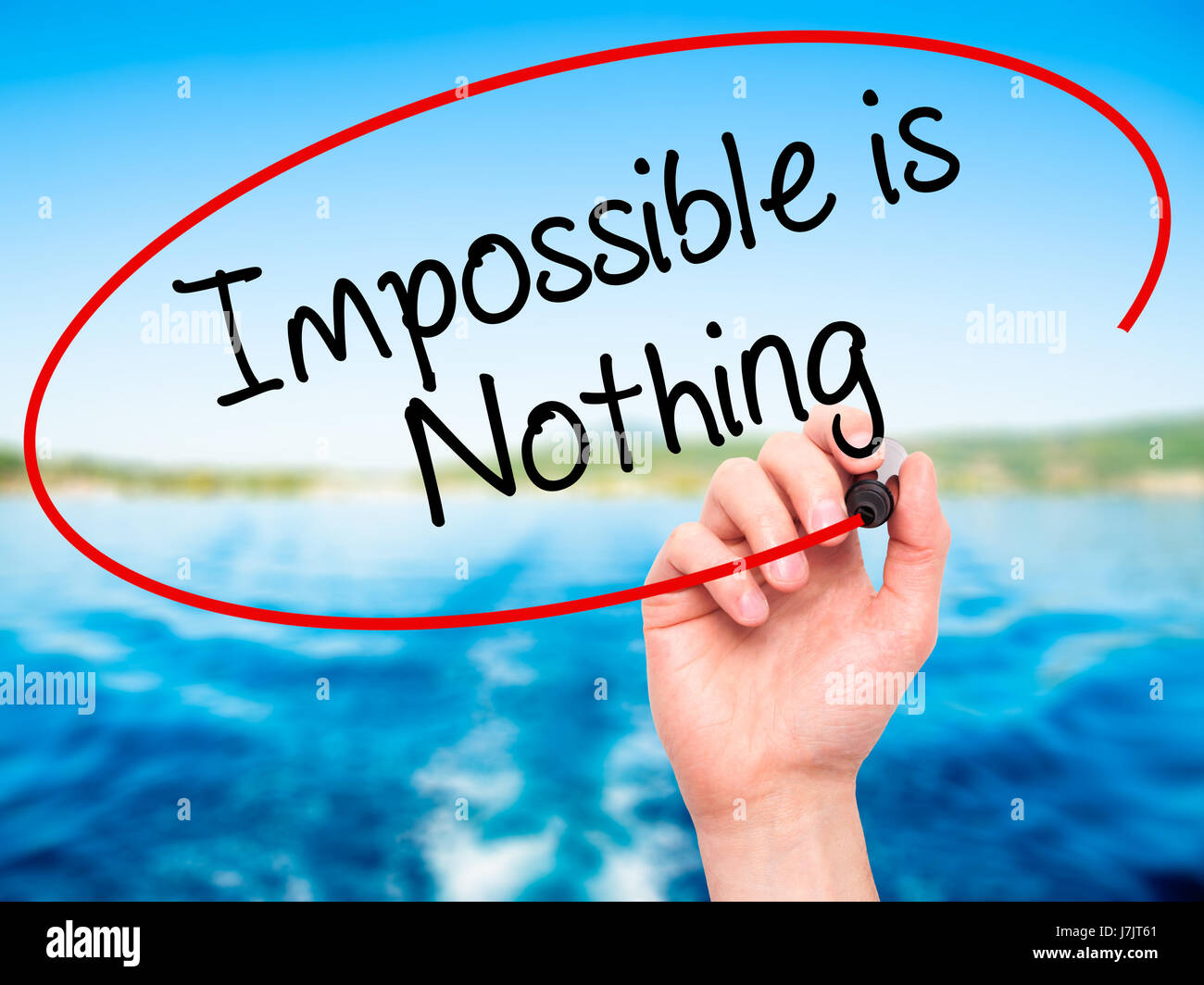 Man Hand writing Impossible is Nothing with black marker on visual ...
