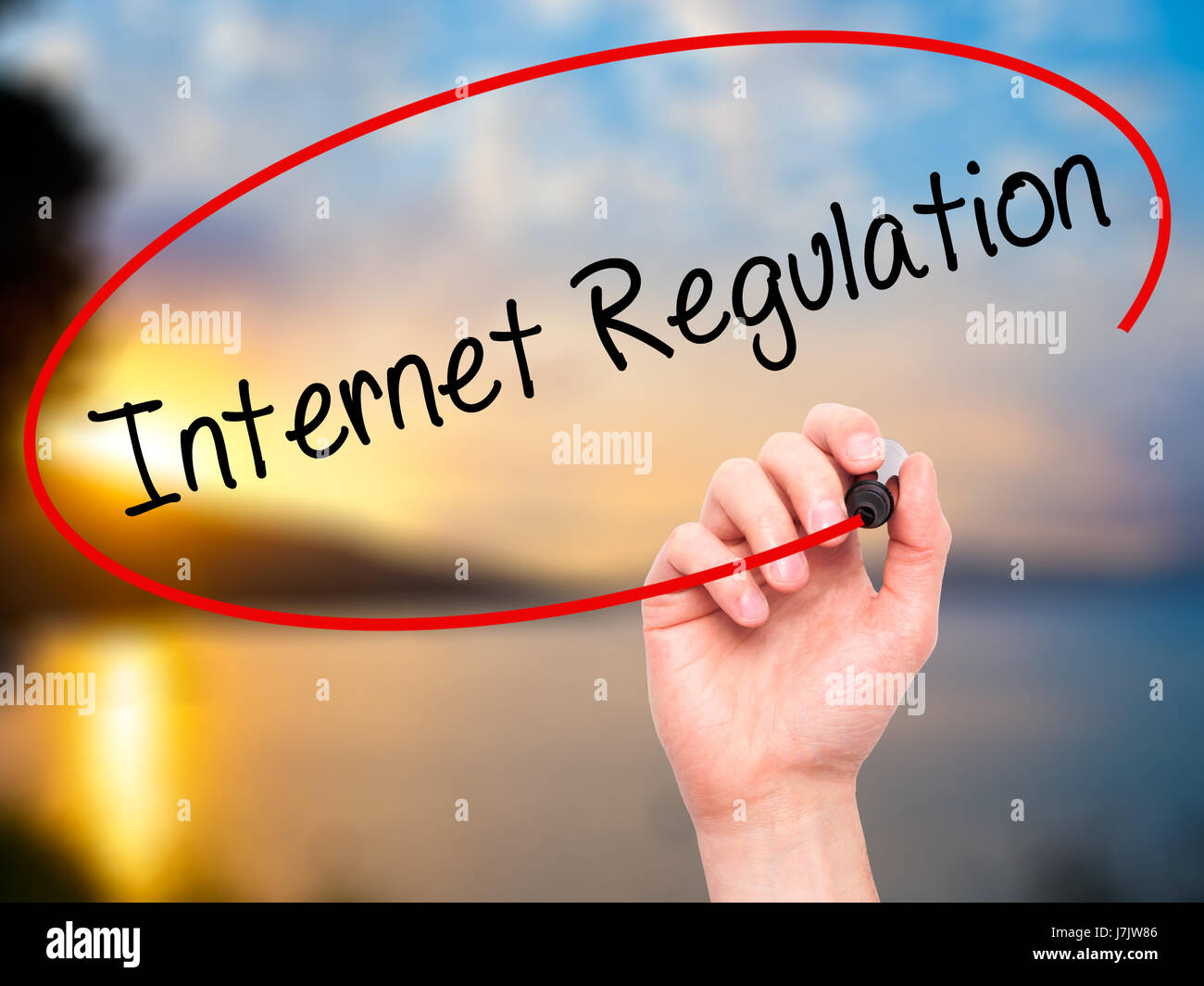 Man Hand writing Internet Regulation with black marker on visual screen ...