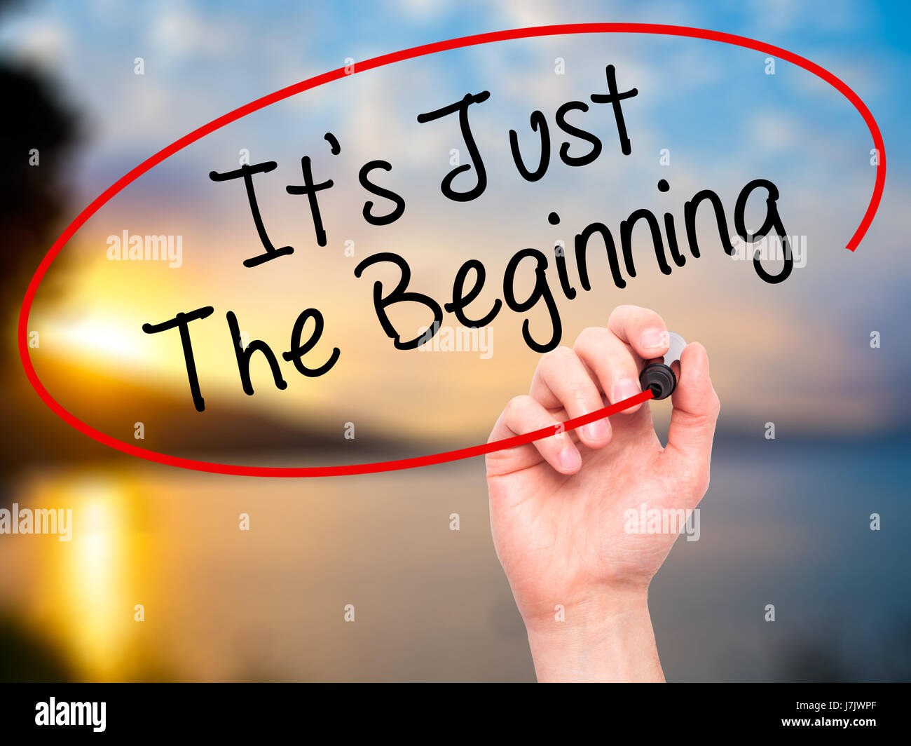 Man Hand writing It's Just The Beginning with black marker on visual ...