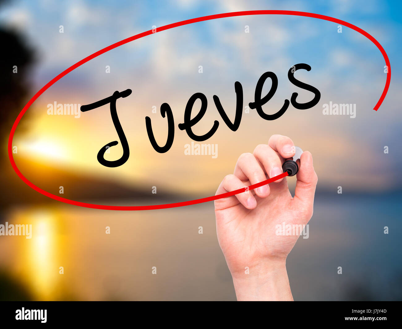 Man Hand writing Jueves (Thursday in Spanish) with black marker on ...