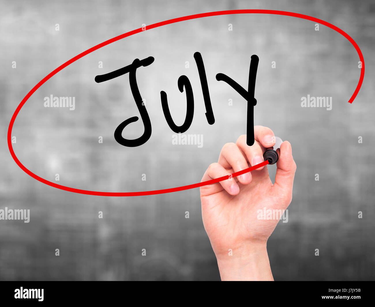 Man Hand writing July with black marker on visual screen. Isolated on ...