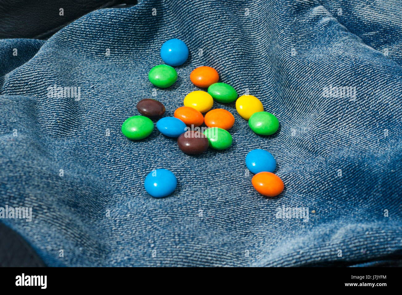 Colorful of chocolate little candies isolated on jeans blue background ...