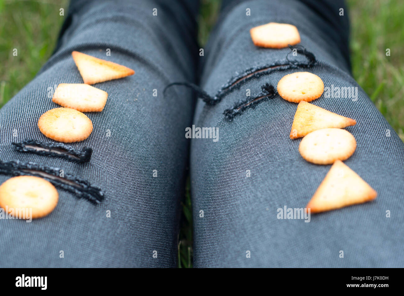 Crackers snack on the legs of a young lady in the park Stock Photo - Alamy