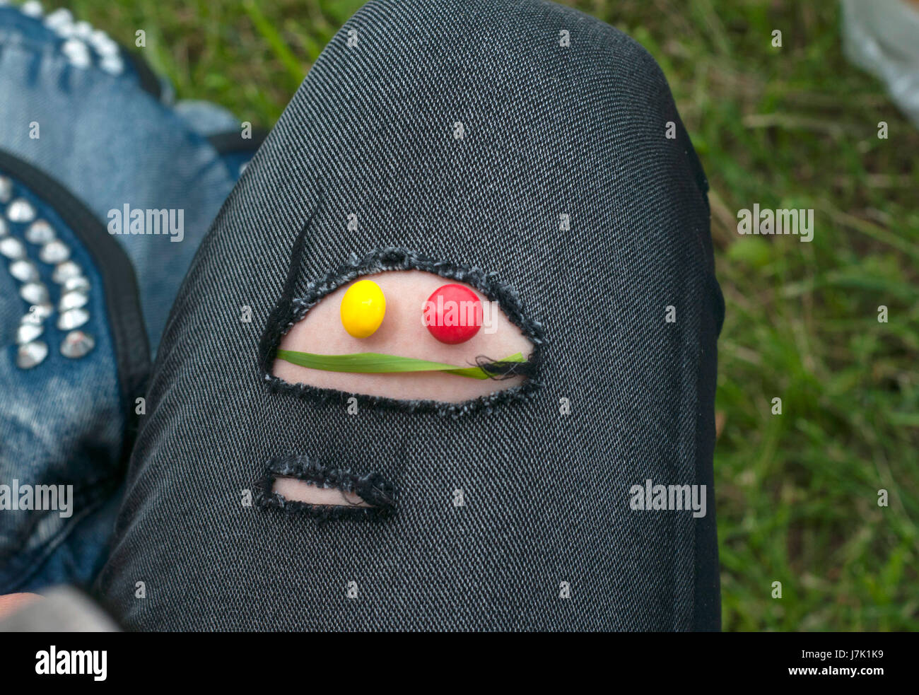 Happy face from m&m candies on the leg of a girl Stock Photo - Alamy