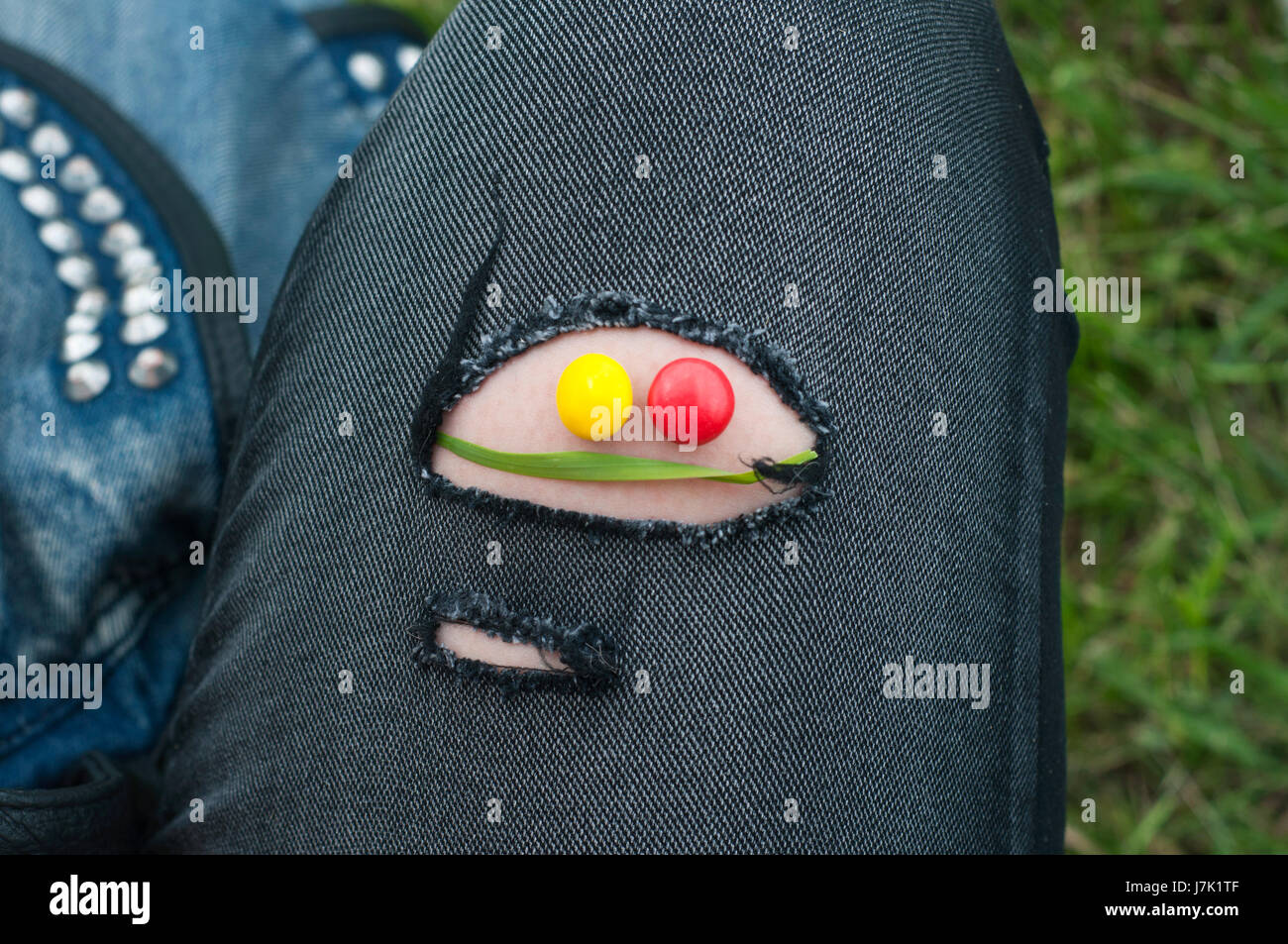Happy face from m&m candies on the leg of a girl Stock Photo - Alamy