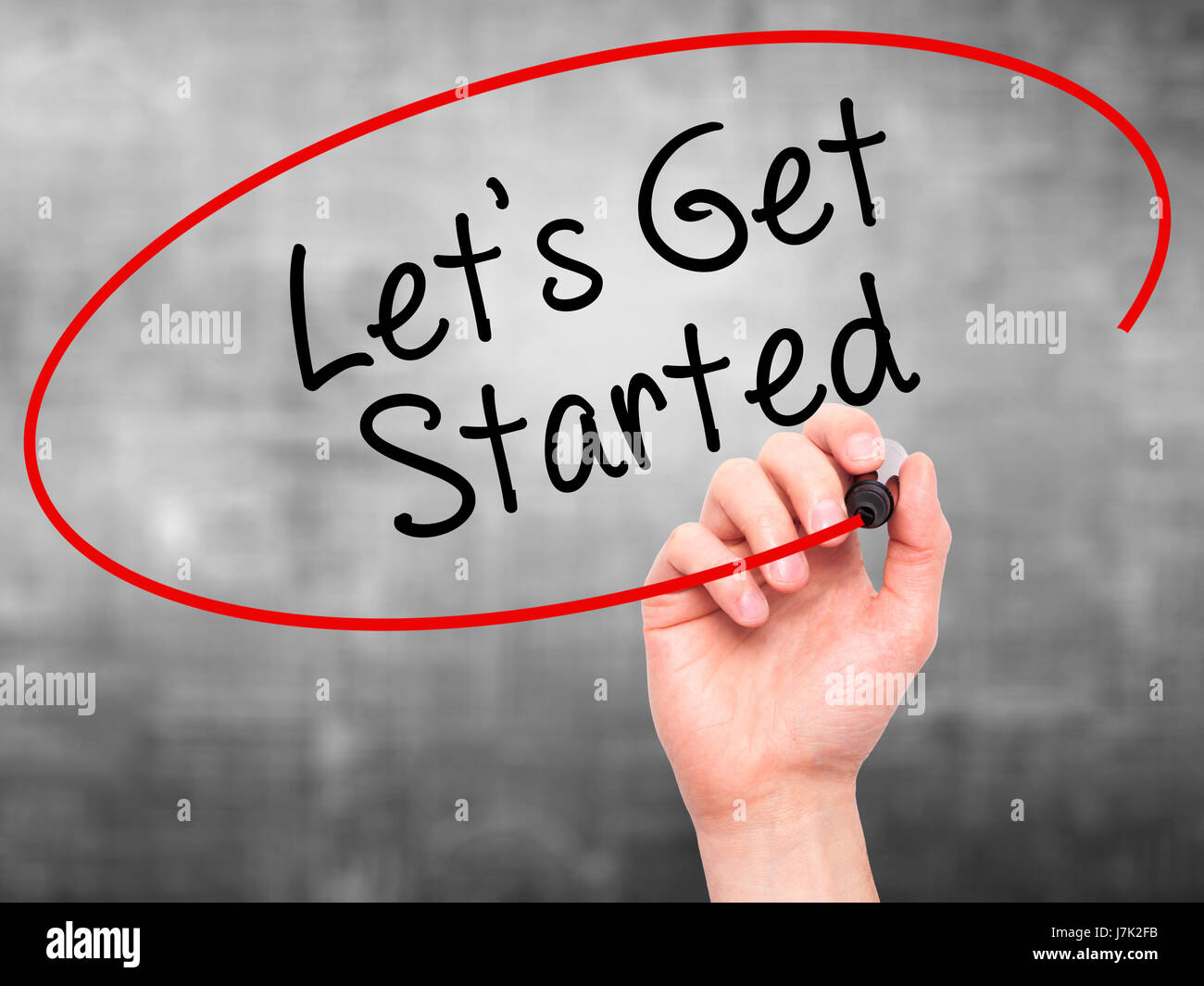 Man Hand writing Lets Get Started with black marker on visual screen ...