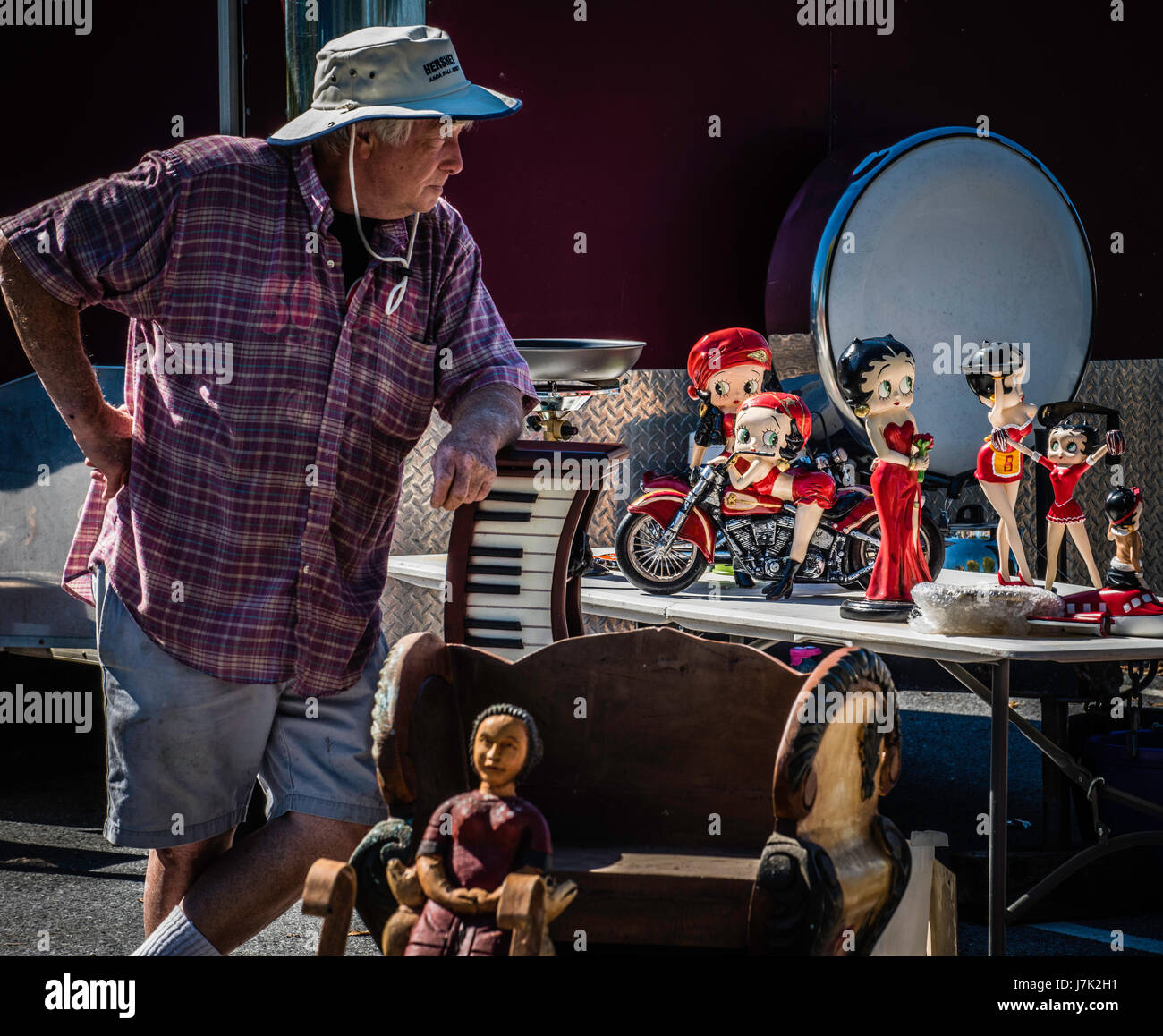 Antique flea market seller with assorted hunorous and kitsch items ...